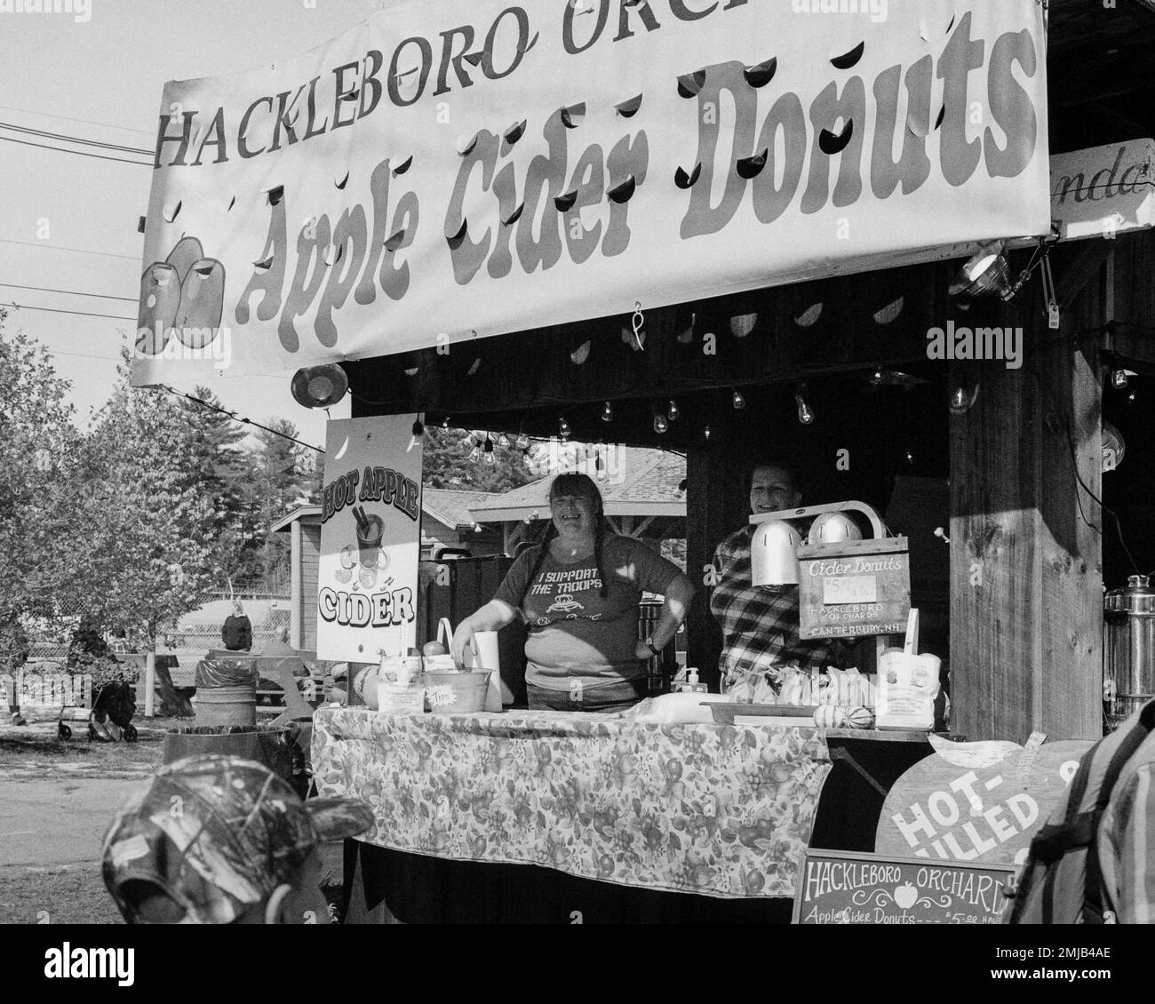 An effervescent couple of servers behind the counter of a vending booth ...