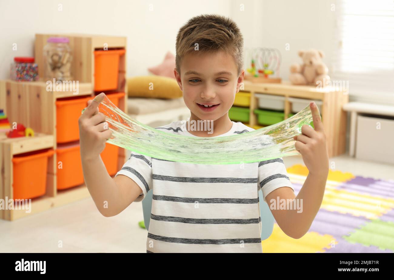 Little boy playing with slime in room Stock Photo - Alamy