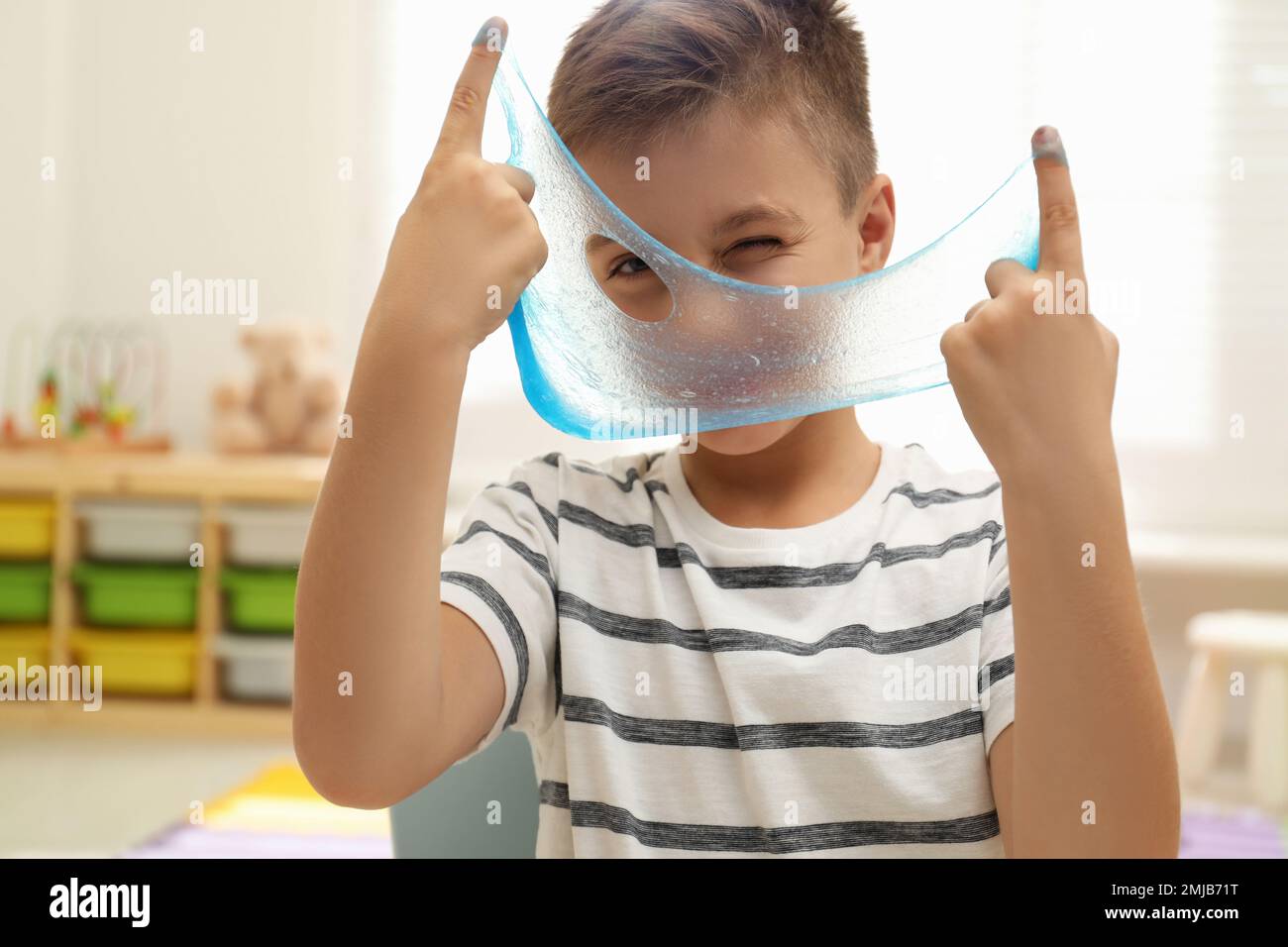 Little boy playing with slime in room Stock Photo - Alamy
