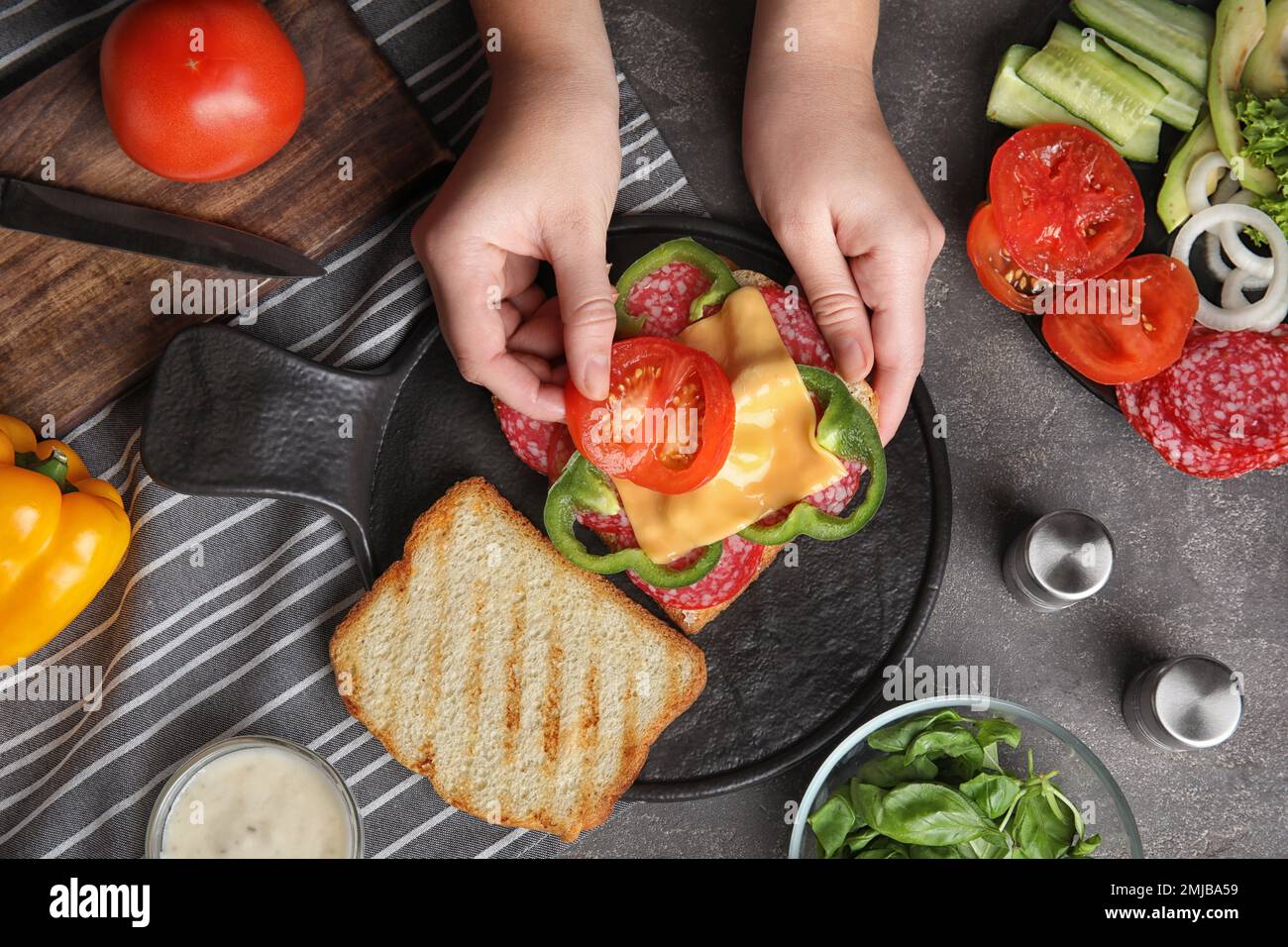 Woman adding tomato sandwich hi-res stock photography and images - Alamy