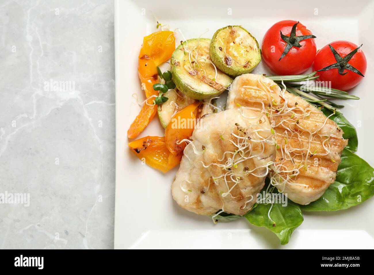 Tasty grilled fish on light grey marble table, top view Stock Photo - Alamy
