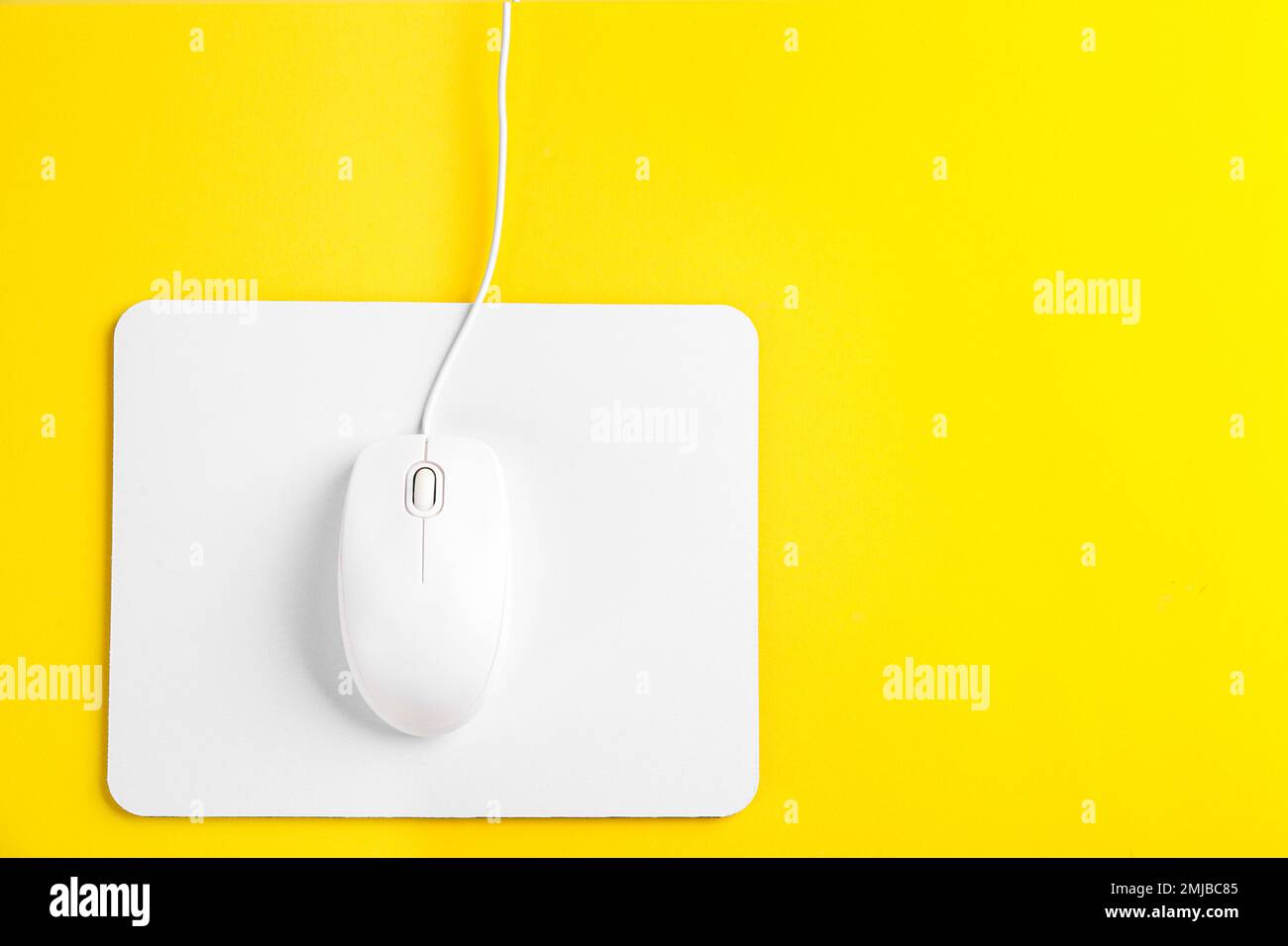 Modern wired optical mouse and pad on yellow background, top view ...