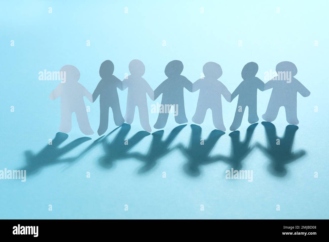 Paper people chain on light blue background. Unity concept Stock Photo ...