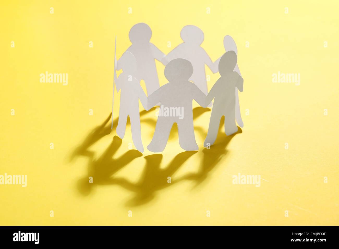 Paper people chain making circle on yellow background. Unity concept ...
