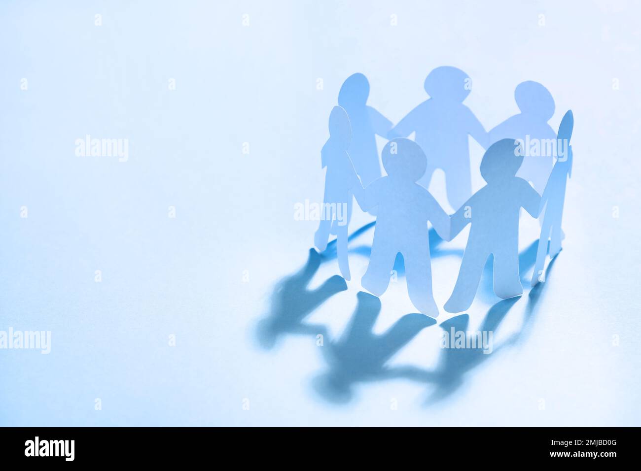 Paper people chain making circle on light blue background, space for ...