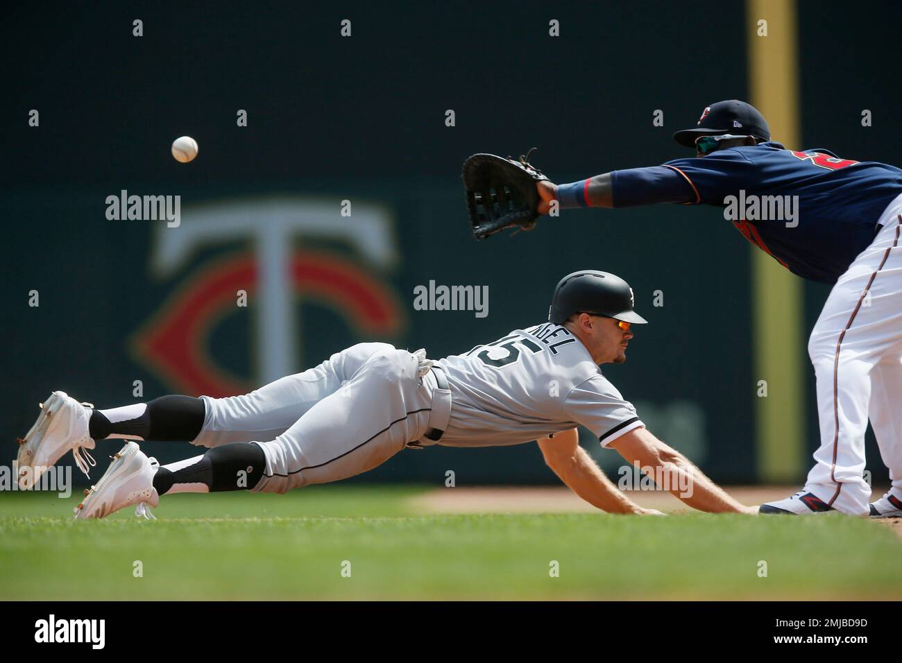 Chicago White Sox's Adam Engel, left, dives safely back to first base ...