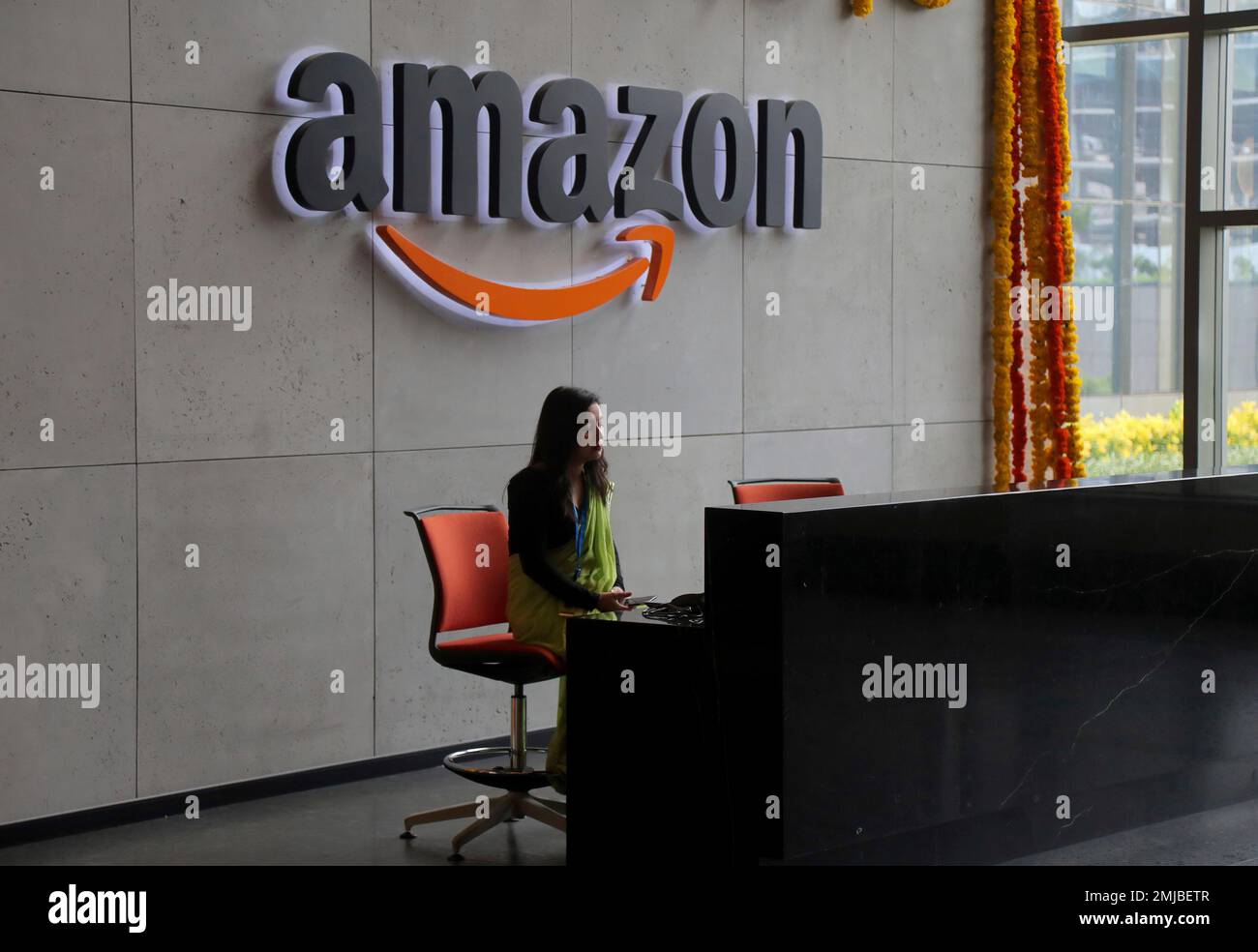An Indian employee works at the reception desk of Amazon's newly ...