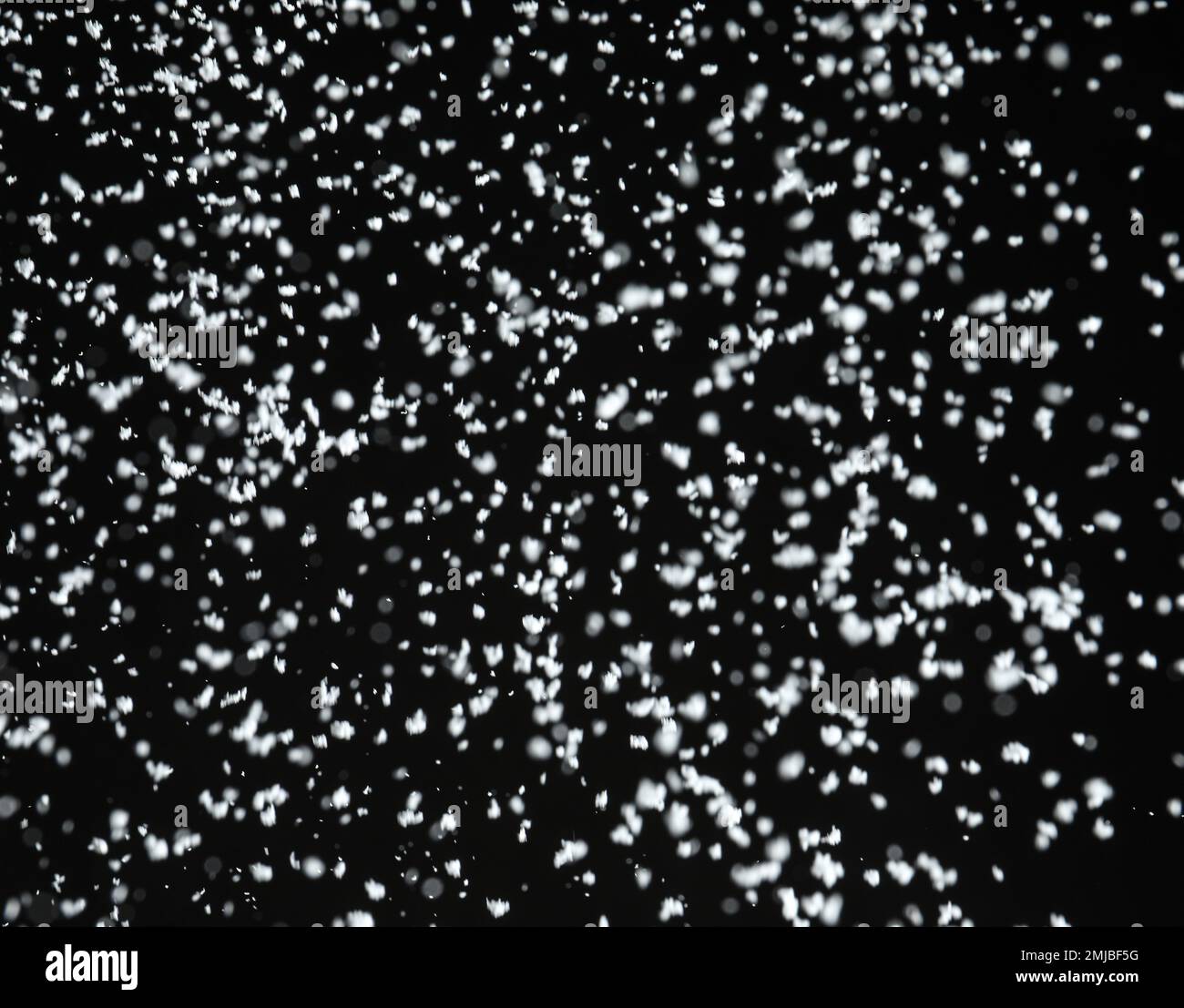 White snow falling down on black background Stock Photo - Alamy