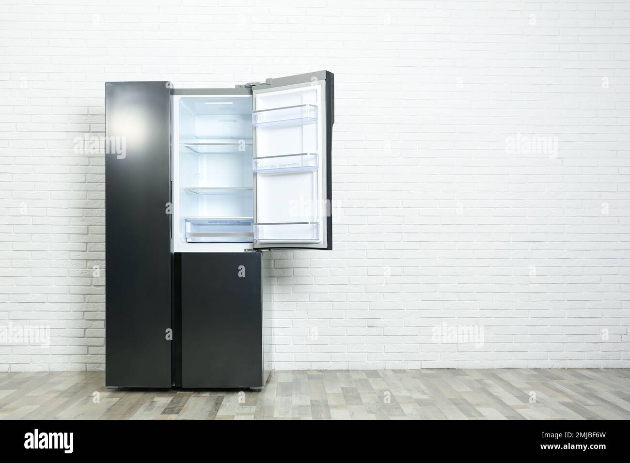 Modern empty refrigerator near white brick wall, space for text Stock ...