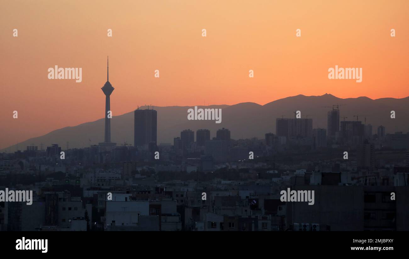 Milad telecommunications tower, left, and buildings are seen at sunset ...