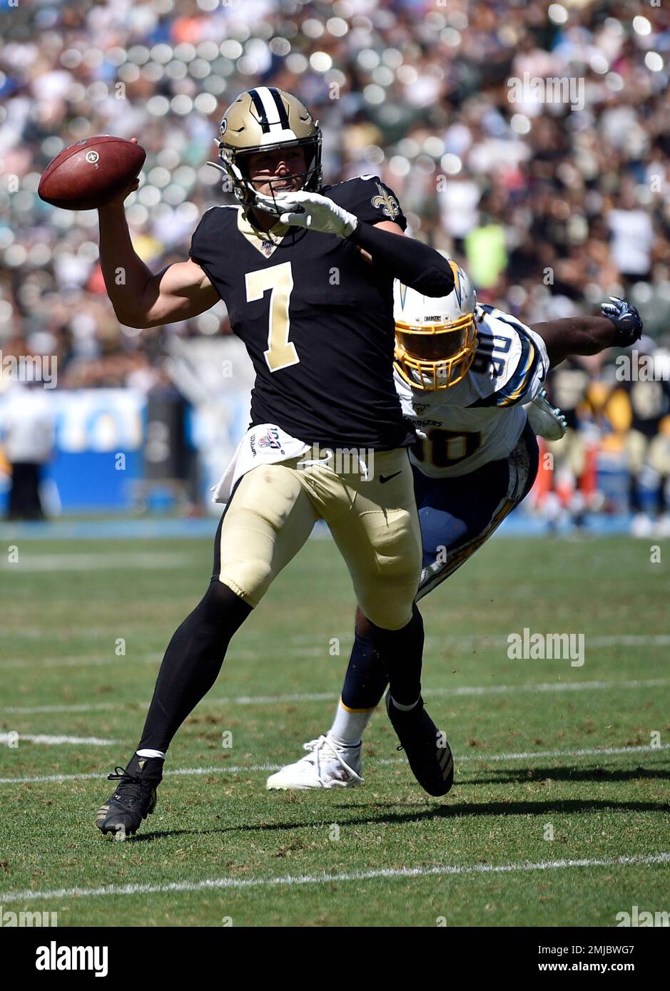 New Orleans Saints quarterback Taysom Hill, left, throws under pressure ...