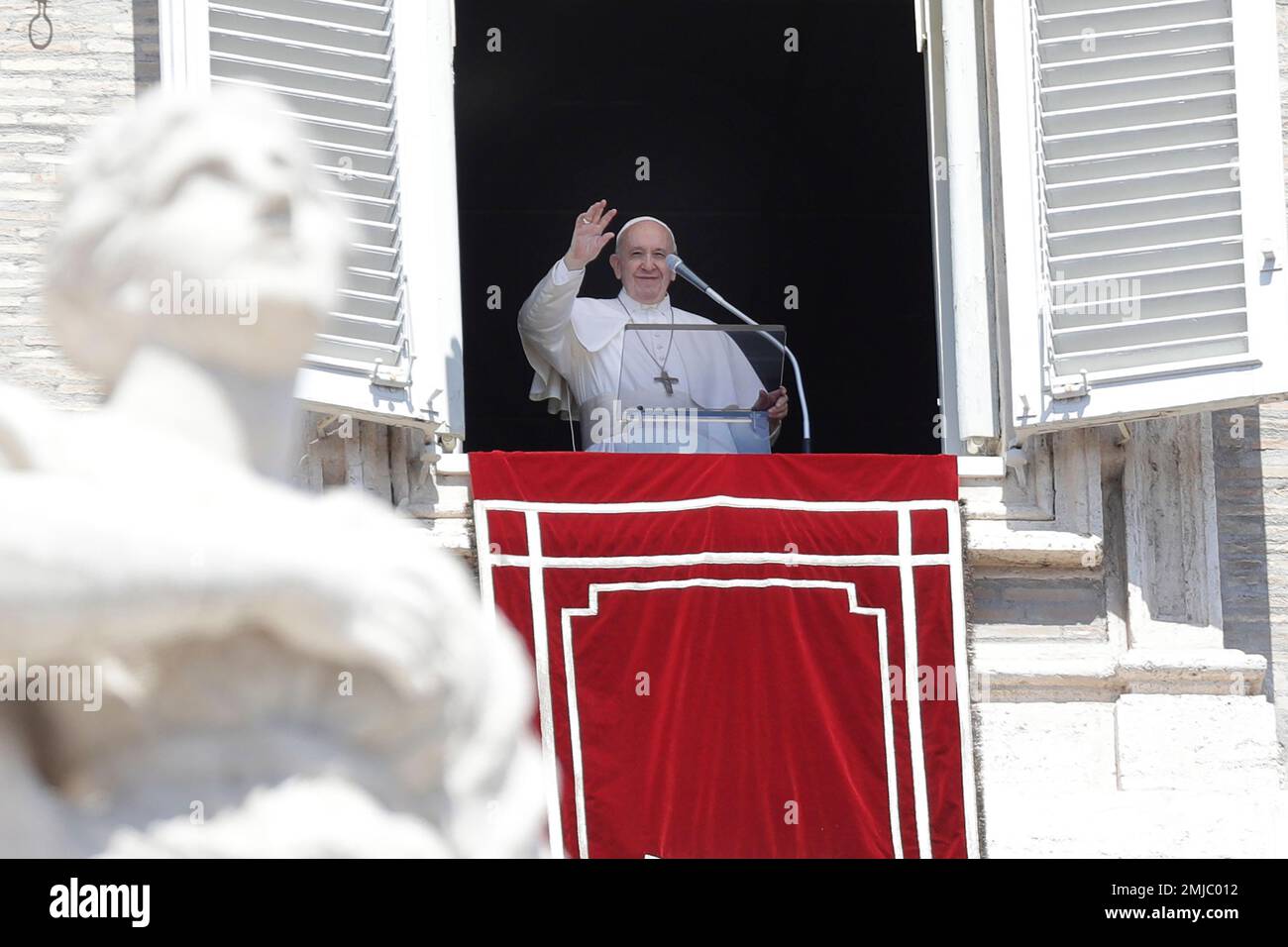 Pope Francis waves to faithful from his studio's window overlooking St ...