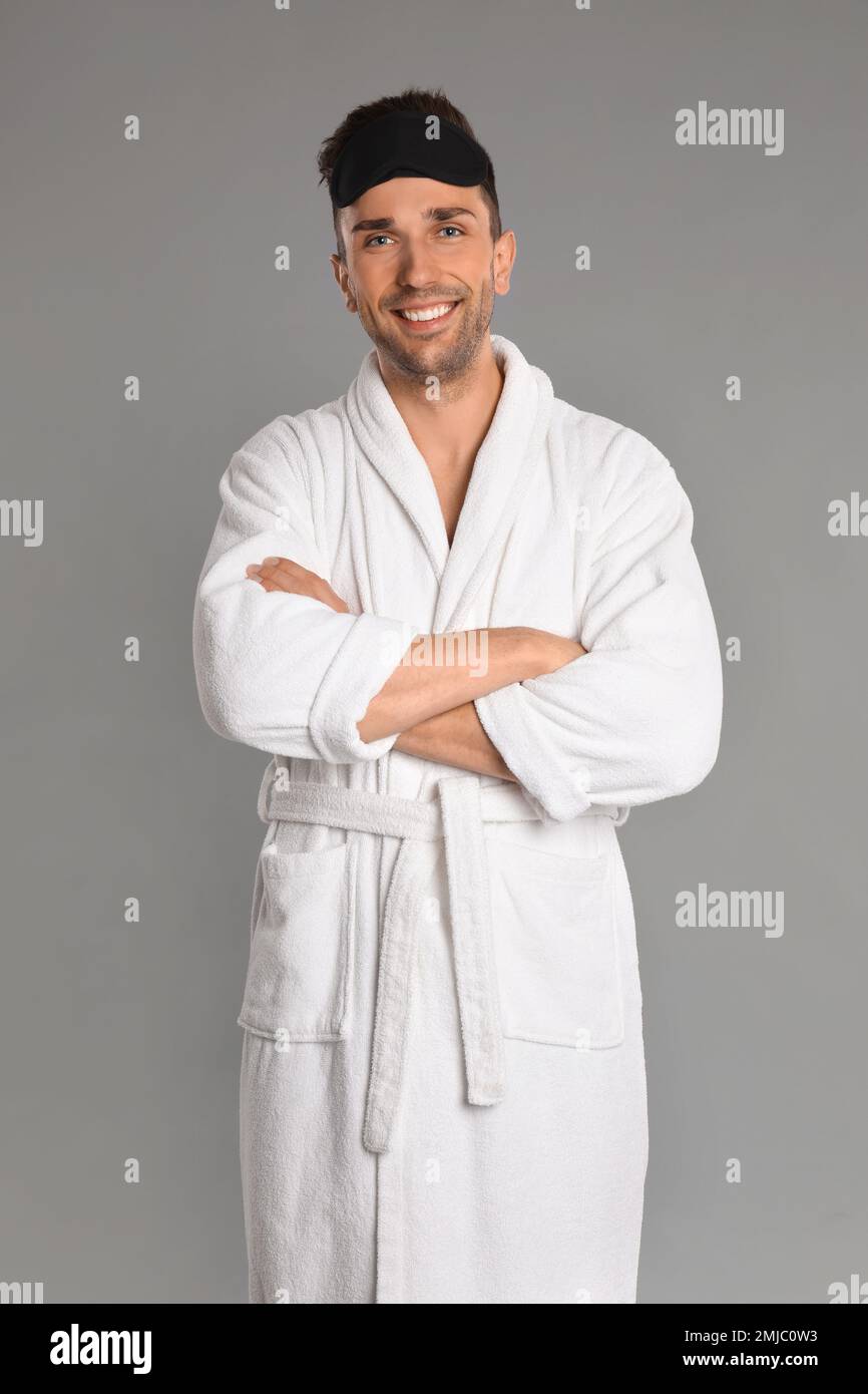 Happy young man in bathrobe on grey background Stock Photo - Alamy