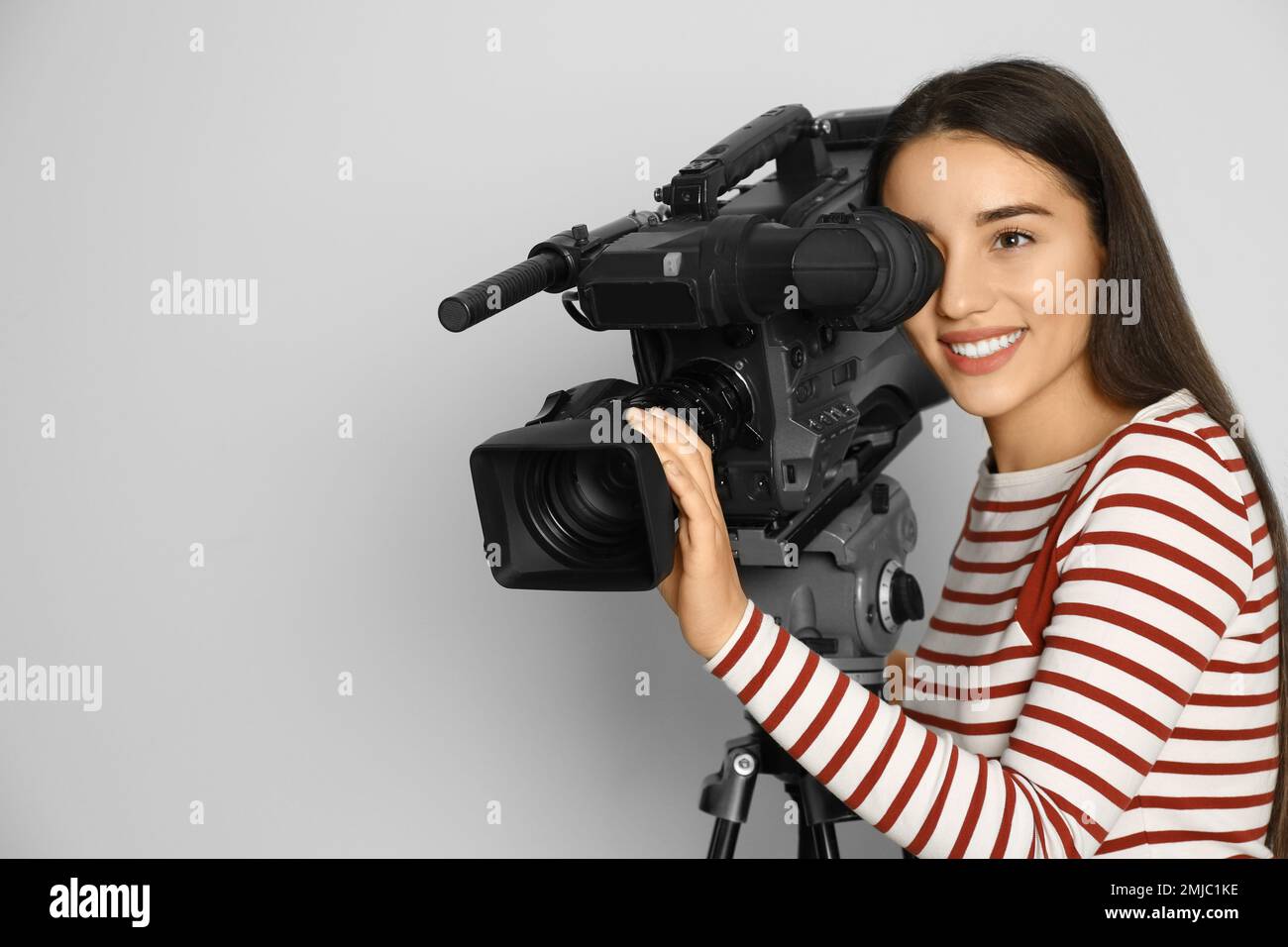 Operator with professional video camera on white background Stock Photo ...