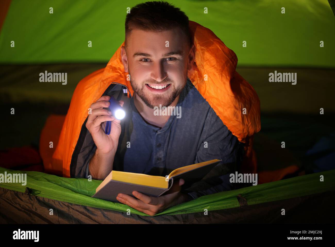 Man flashlight reading book hi-res stock photography and images - Alamy