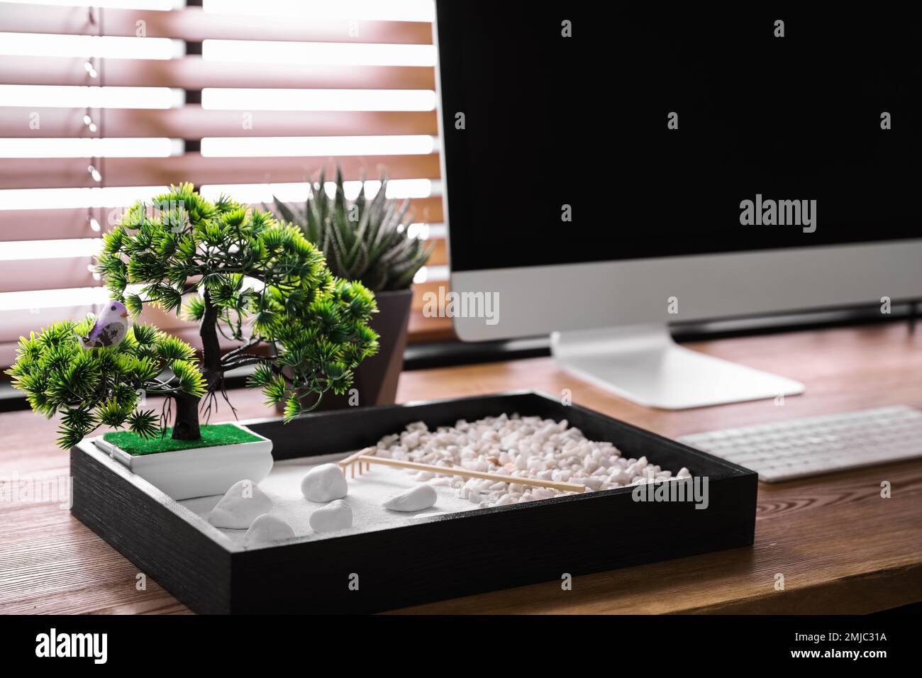 Modern workplace with beautiful miniature zen garden and computer in ...