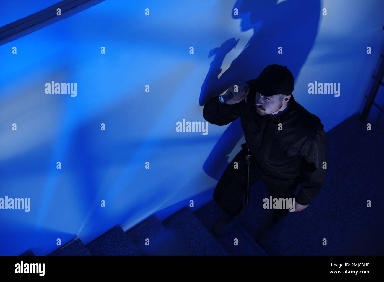 Male security guard with flashlight going up stairs in darkness Stock ...