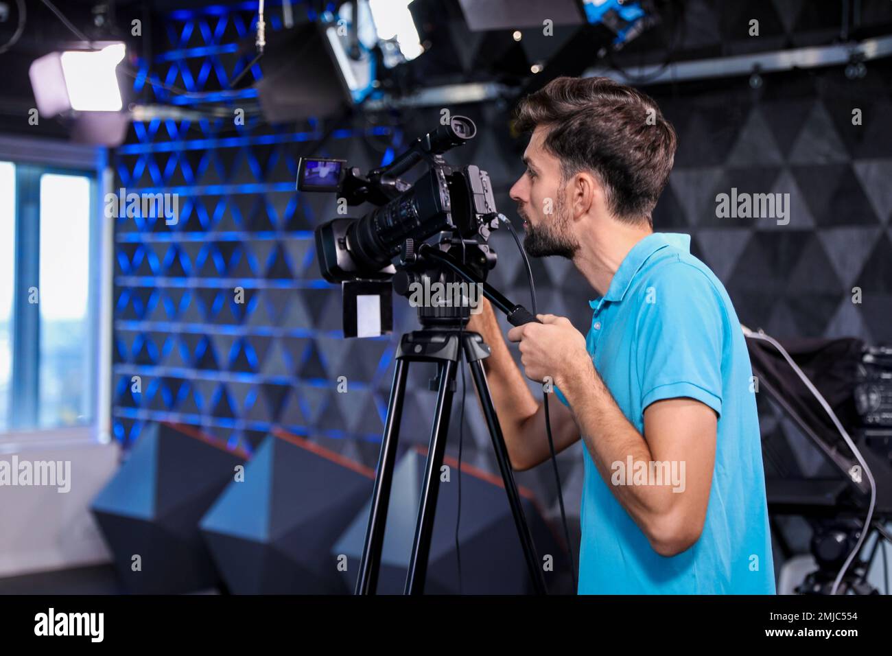 Professional video camera operator working in studio Stock Photo - Alamy