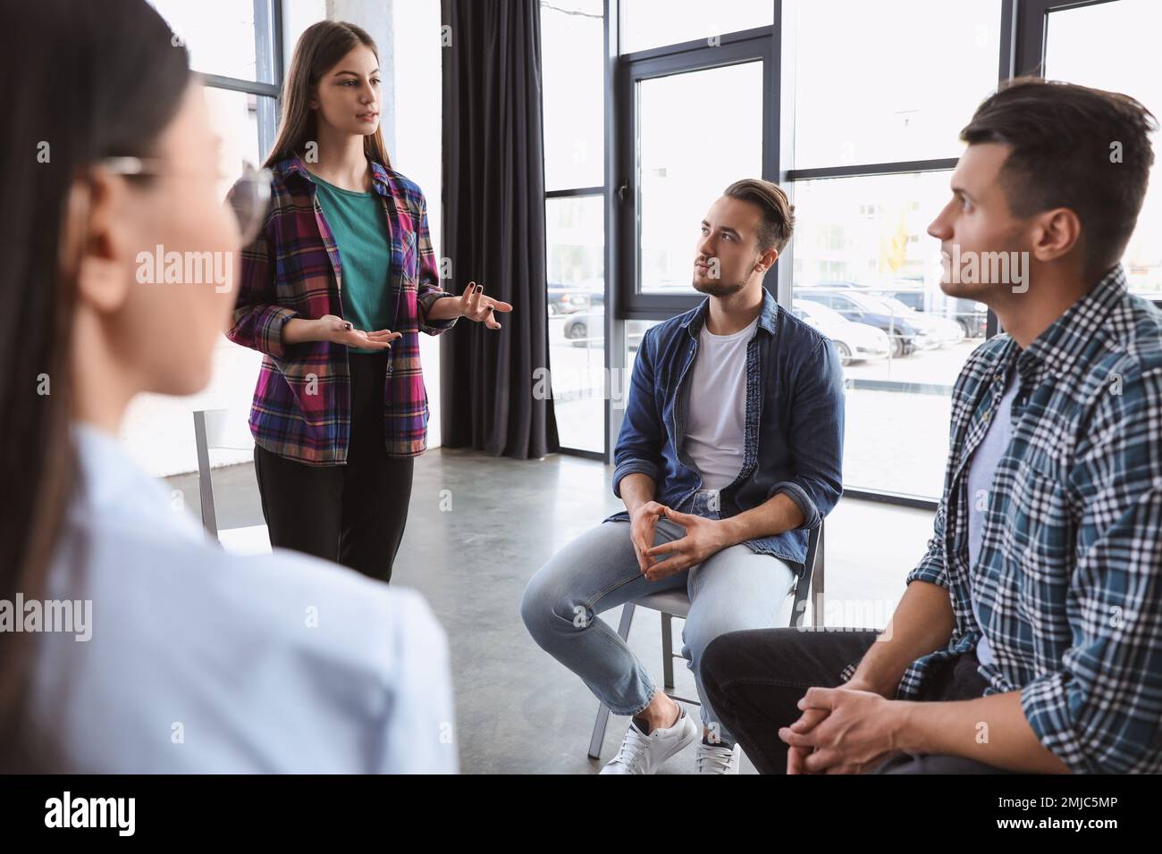 Psychotherapist working with patients in group therapy session indoors ...