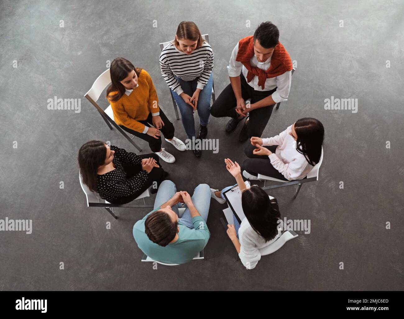 Psychotherapist working with patients in group therapy session, top ...
