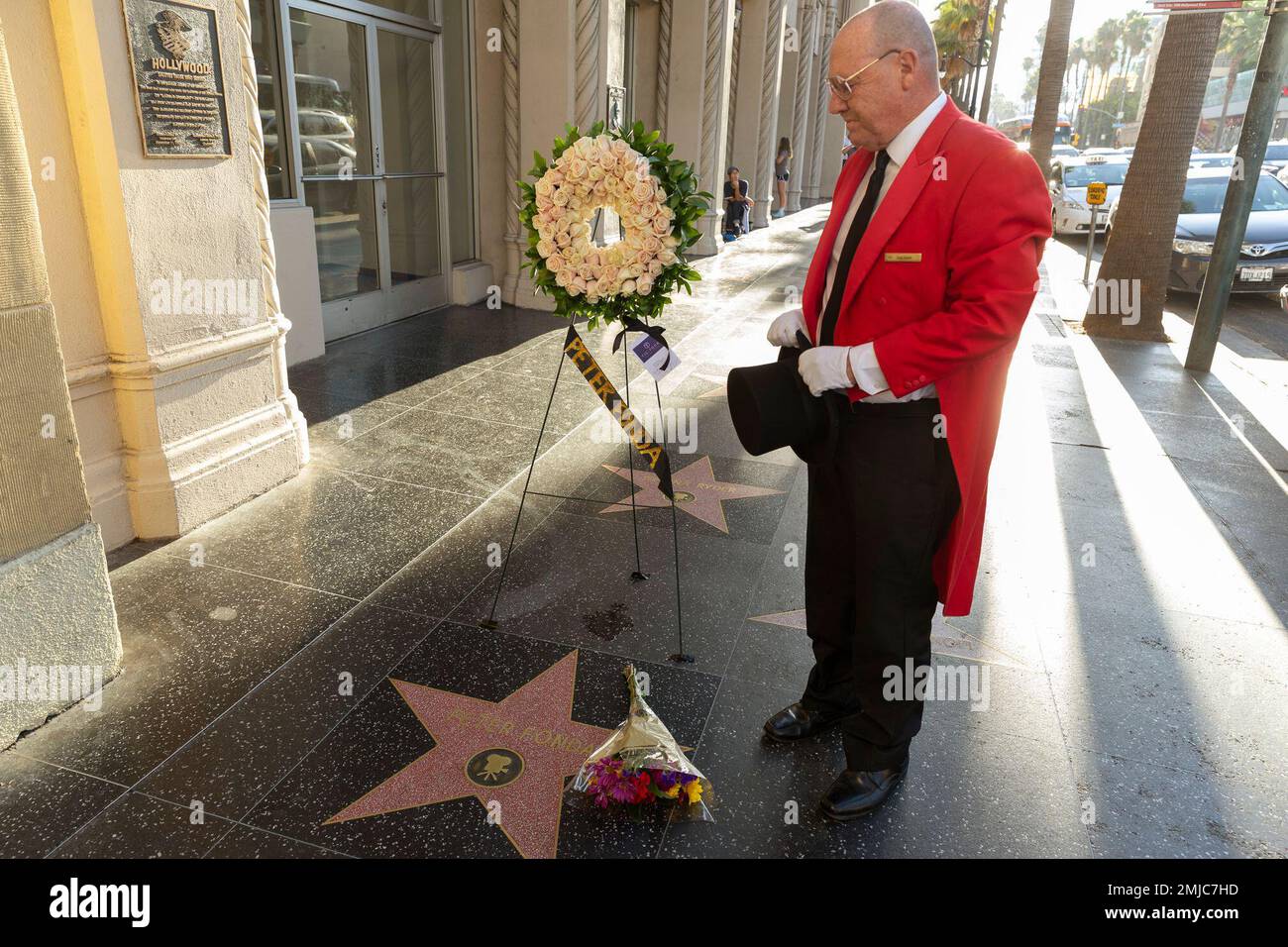 Unofficial Hollywood ambassador Gregg Donovan sets flowers on the Walk ...