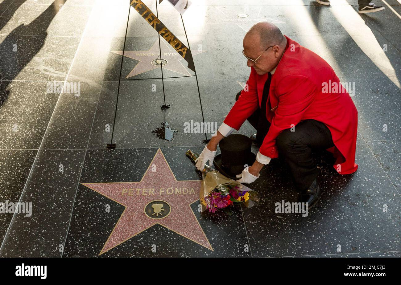 Unofficial Hollywood ambassador Gregg Donovan sets flowers on the Walk ...