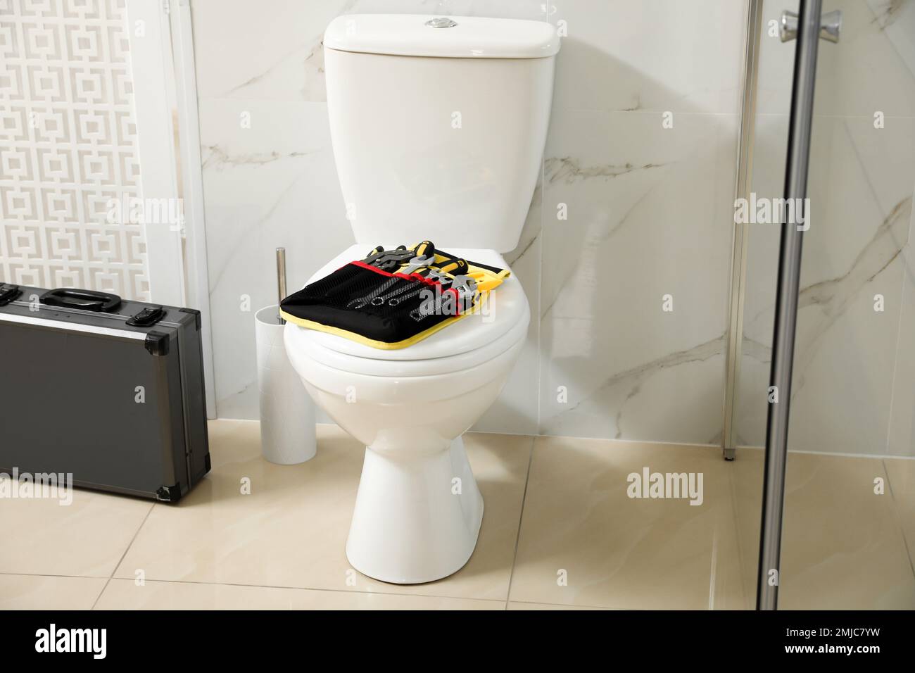 Plumber's tools on toilet bowl in bathroom Stock Photo - Alamy