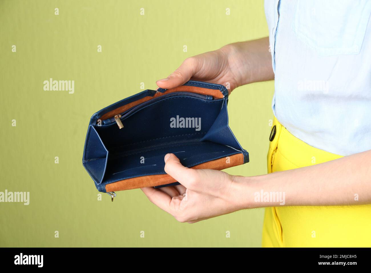 Woman showing empty wallet on light green background, closeup Stock ...