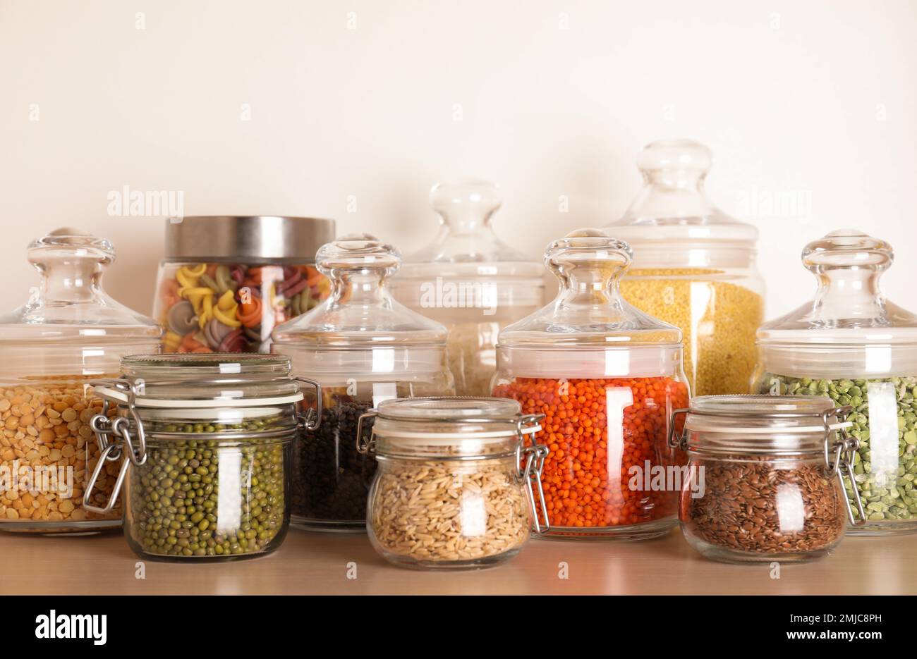 Glass jars with different types of groats on wooden shelf Stock Photo ...