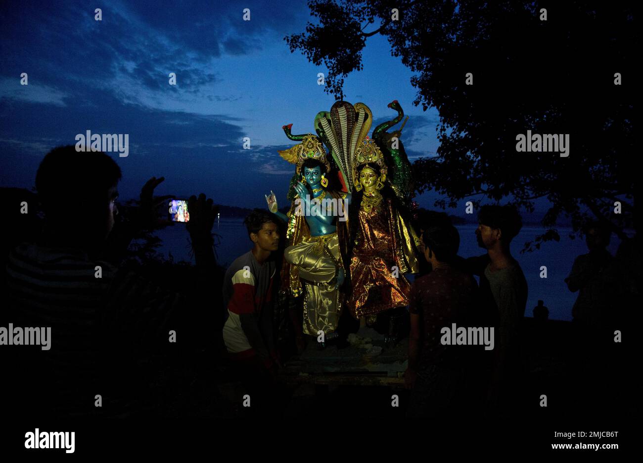 Indian boys carry an idol of Hindu God Krishna and his consort Radha ...