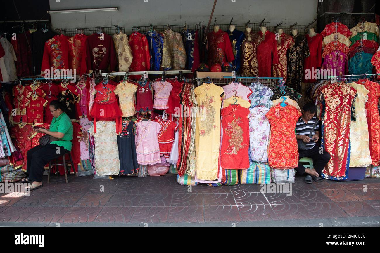 Thai vendors wait for customers at their sidewalk shop in Bangkok ...