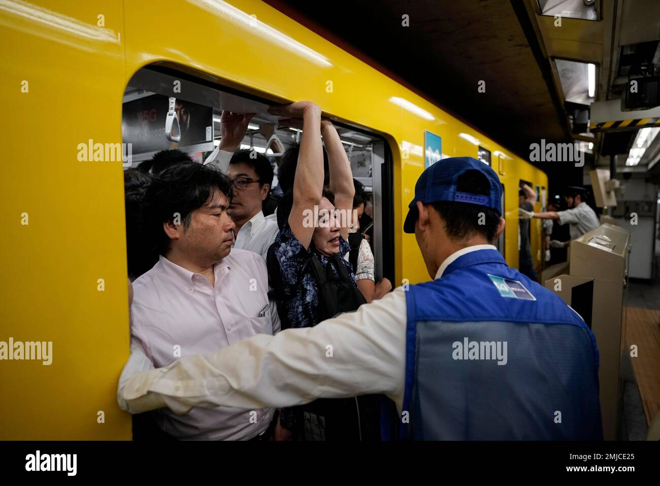 In this July 30, 2019, photo, a station attendant watches as a commuter ...
