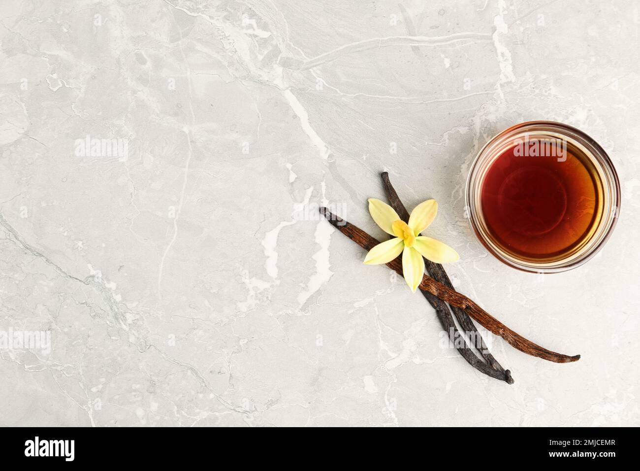 Flat lay composition with vanilla extract on light grey marble table ...