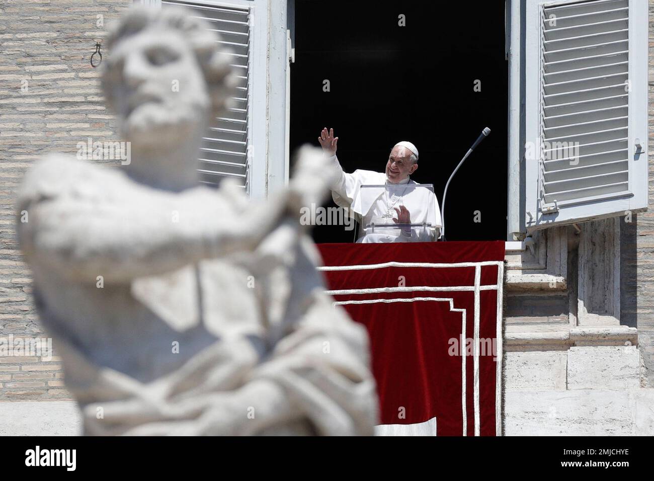 Pope Francis waves to faithful from his studio window overlooking St ...