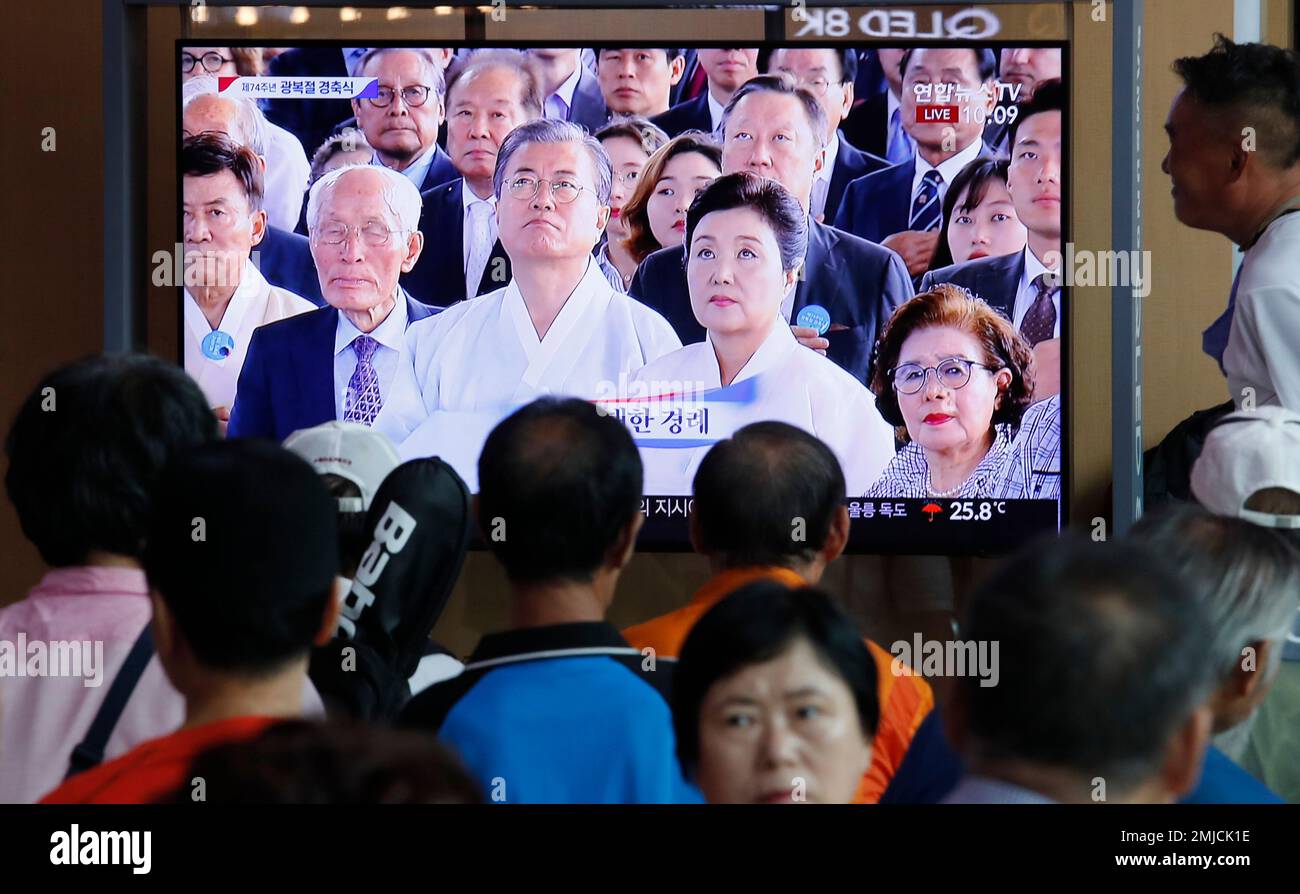 People watch a TV screen showing a live broadcast of South Korean ...