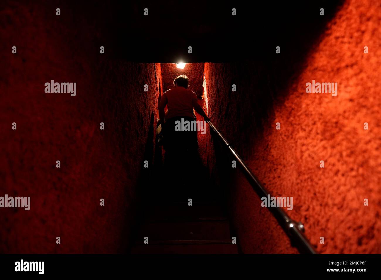 In this Friday, July 26, 2019, photo, a man walks up a narrow staircase ...