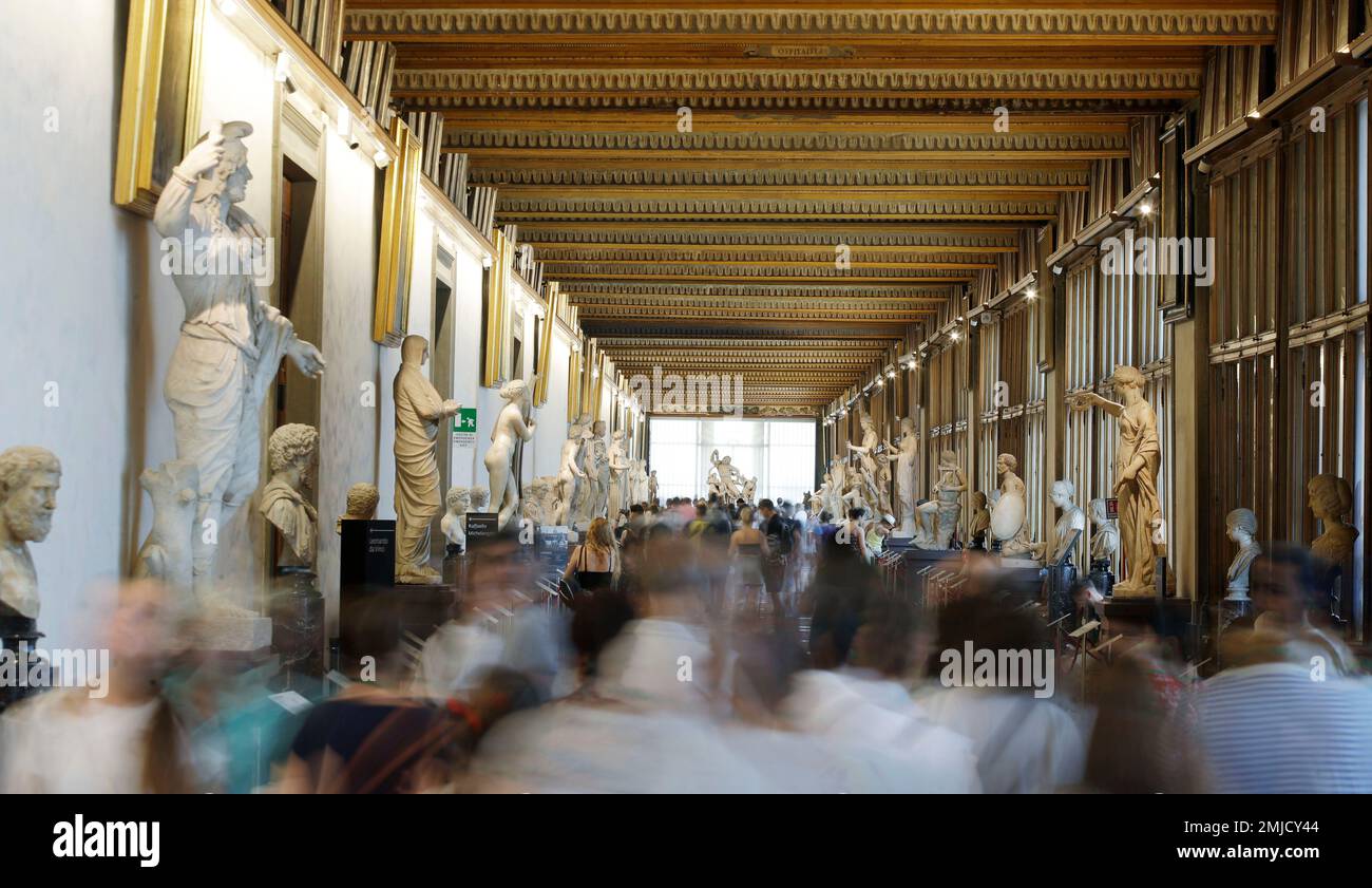 Visitors walk through corridors of the Uffizi Gallery Museum, in ...
