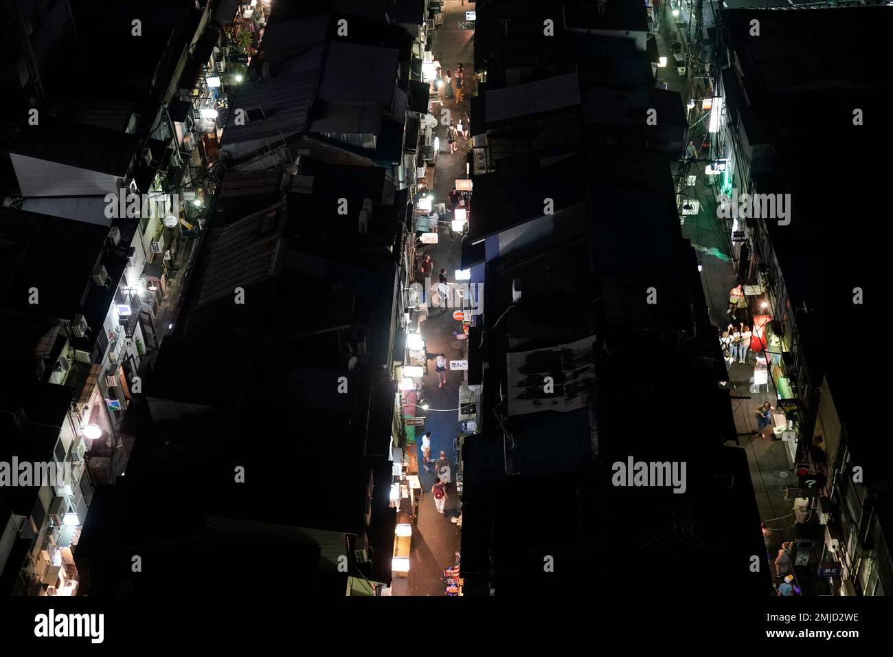 People walk through narrow alleyways clustered with tiny bars and ...