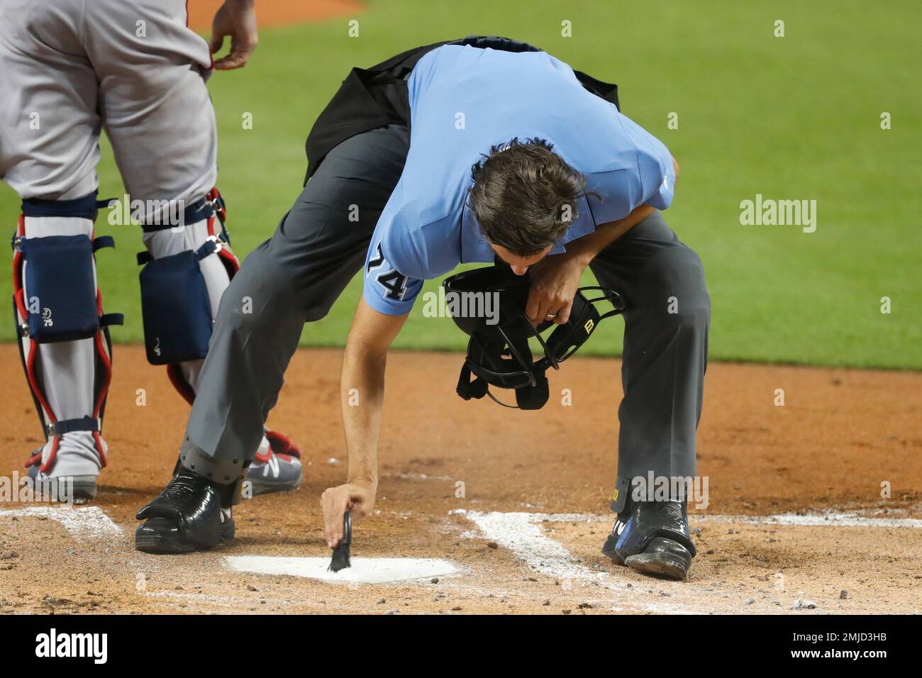 Home plate umpire John Tumpane cleans off home plate before the next ...