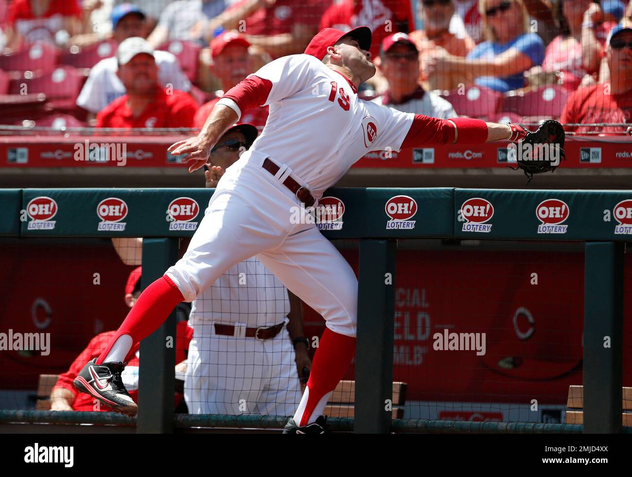 Cincinnati Reds first baseman Joey Votto leans into the dugout to catch ...