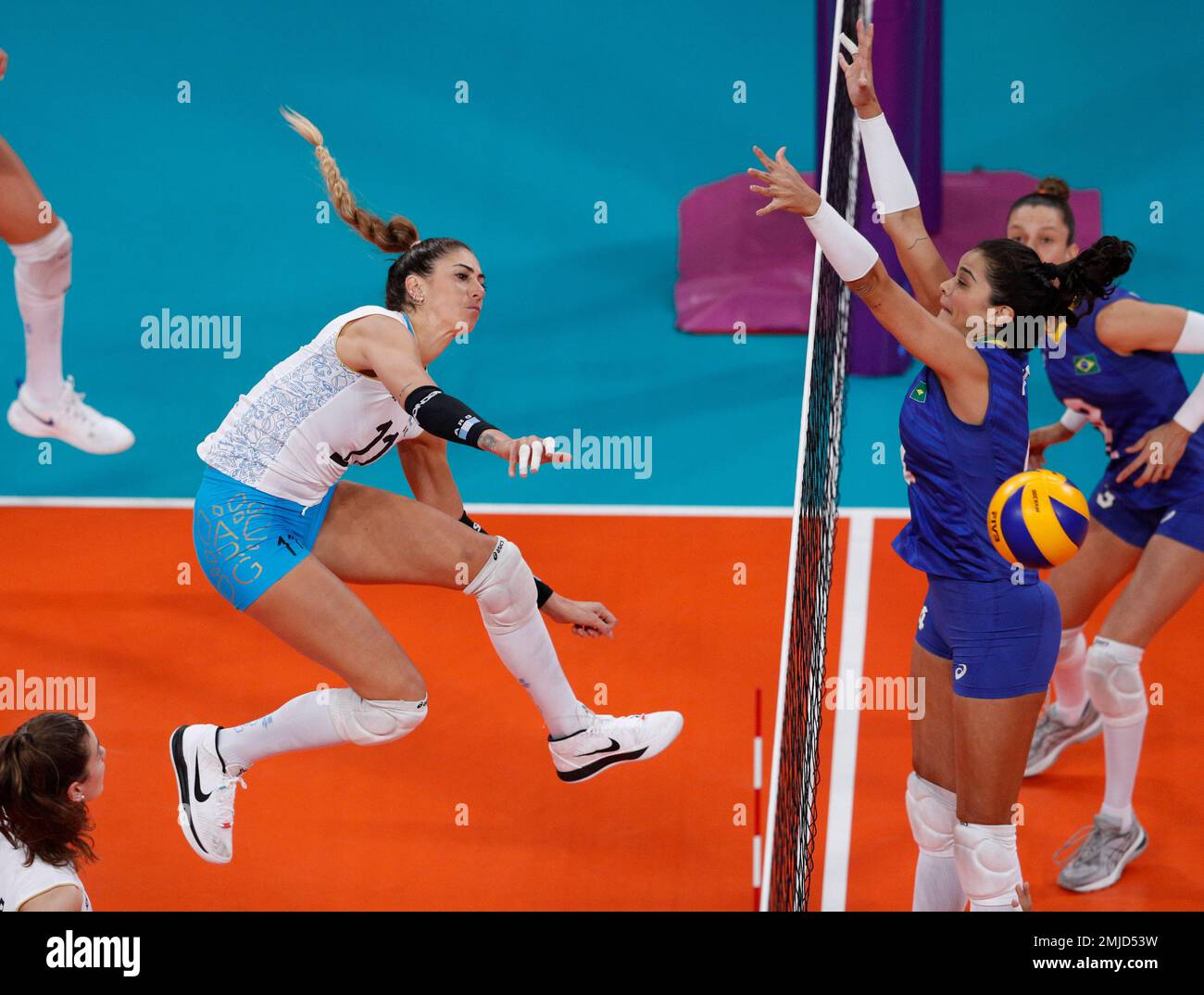 Argentina's Julieta Lazcano spikes past Brazilian players in their ...
