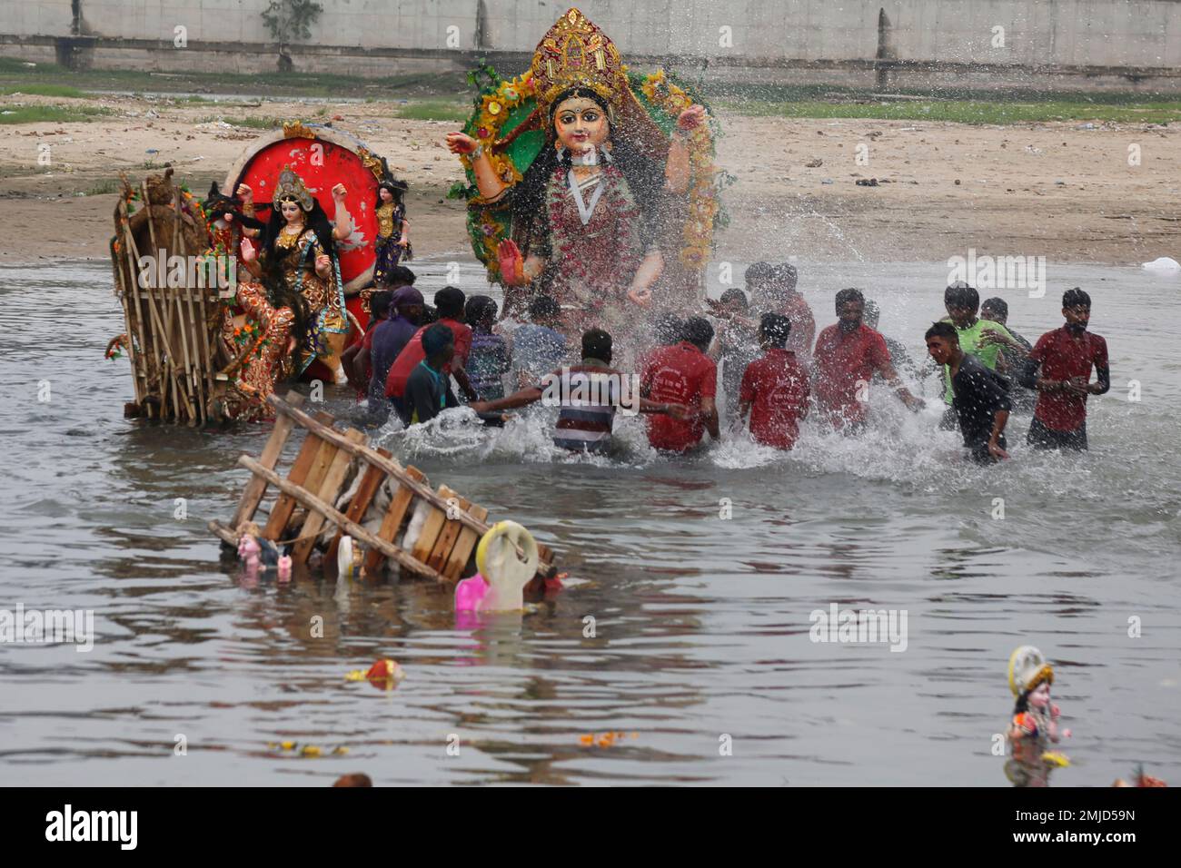 Indian devotees immerse an idol of Hindu goddess Dashama in river ...