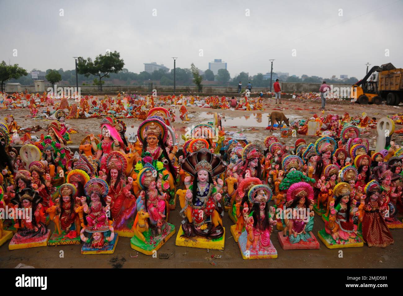 Idols of Hindu goddess Dashama lie on a pavement on the bank of river ...