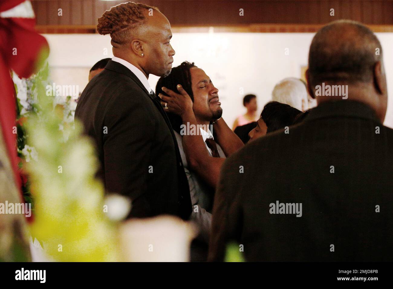 A relative attempts to console Dion Green, center, before the funeral ...