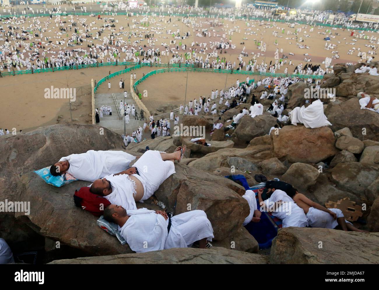 Muslim pilgrims take a nap on a rocky hill known as Mountain of Mercy ...