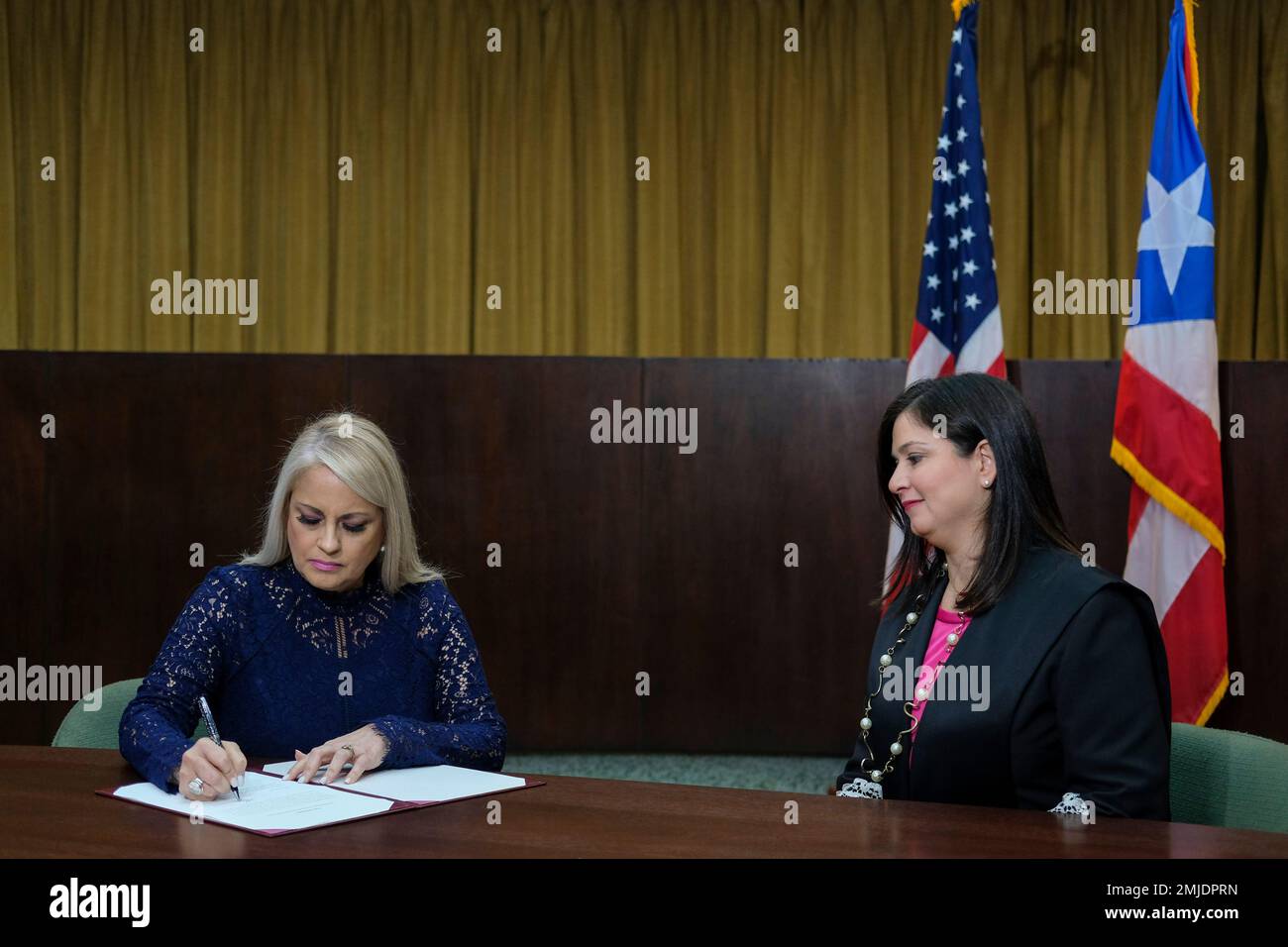 Justice Secretary Wanda Vazquez signs a document after she was sworn in ...