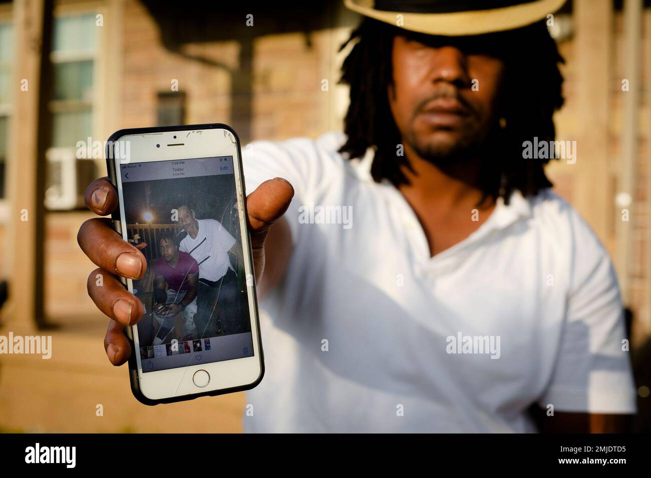 Dion Green holds a cell phone showing a picture of himself and his ...