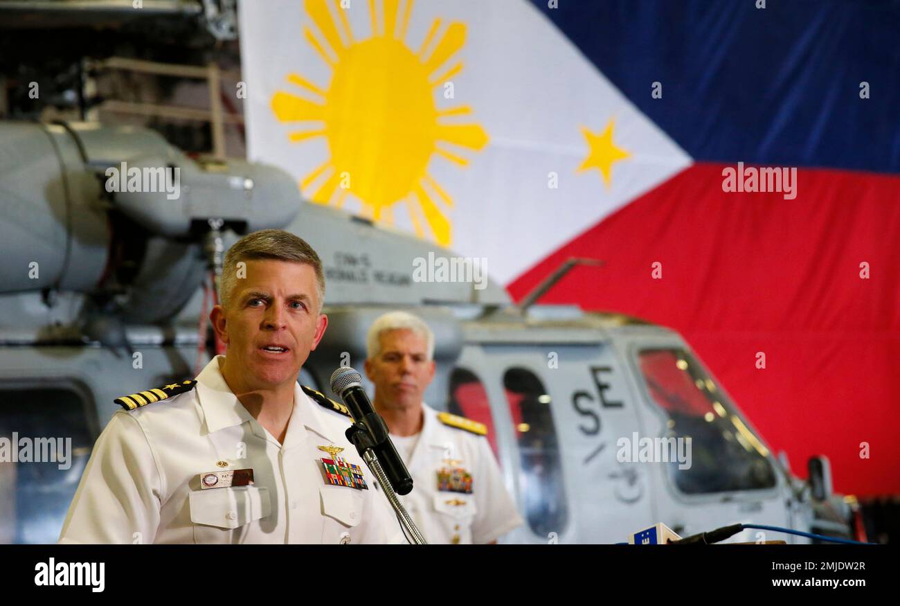 With the Philippine flag in the background, U.S. Navy Capt. Pat ...