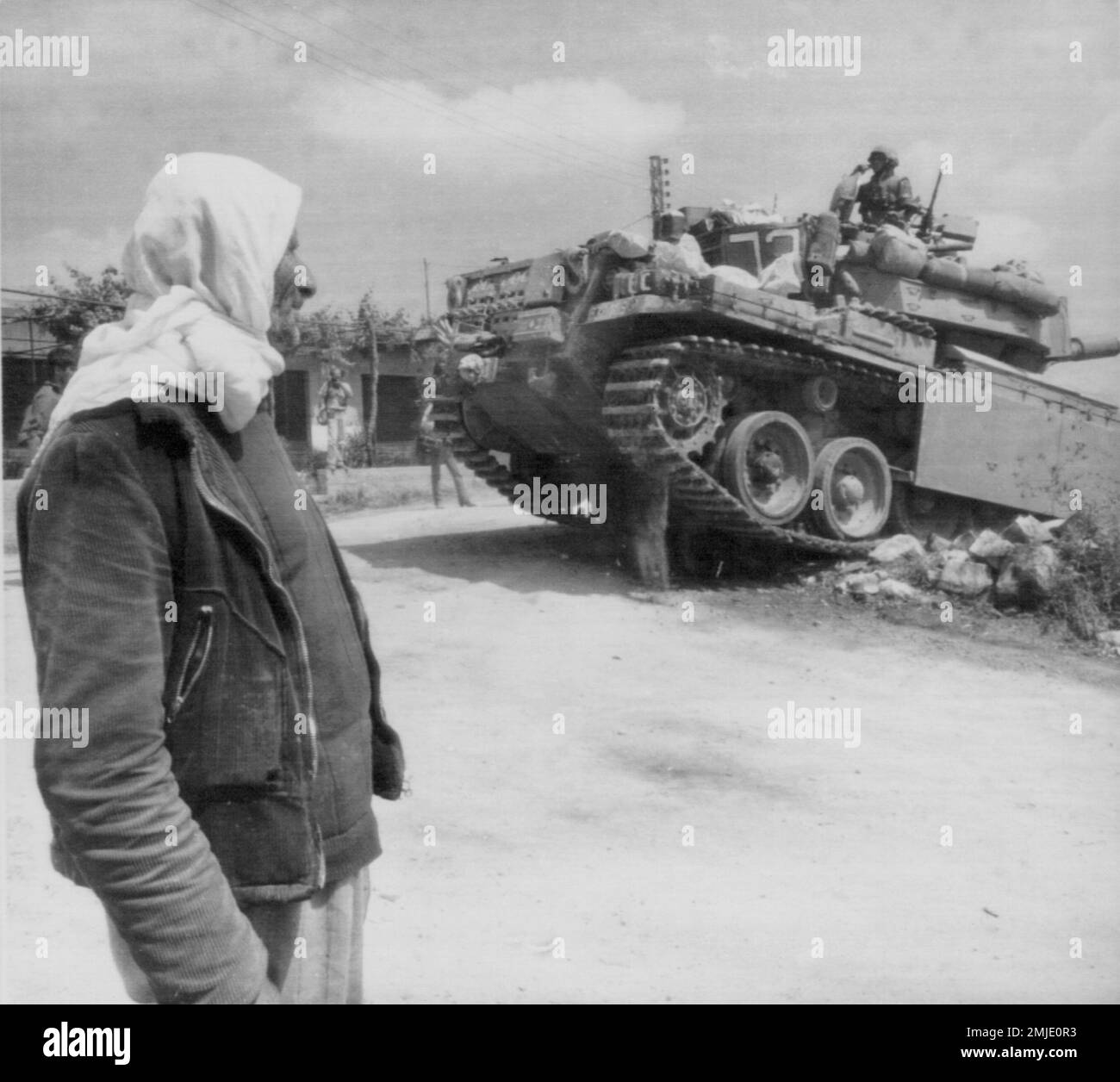 A Lebanese villager watches an Israeli army tank clear the road inside ...