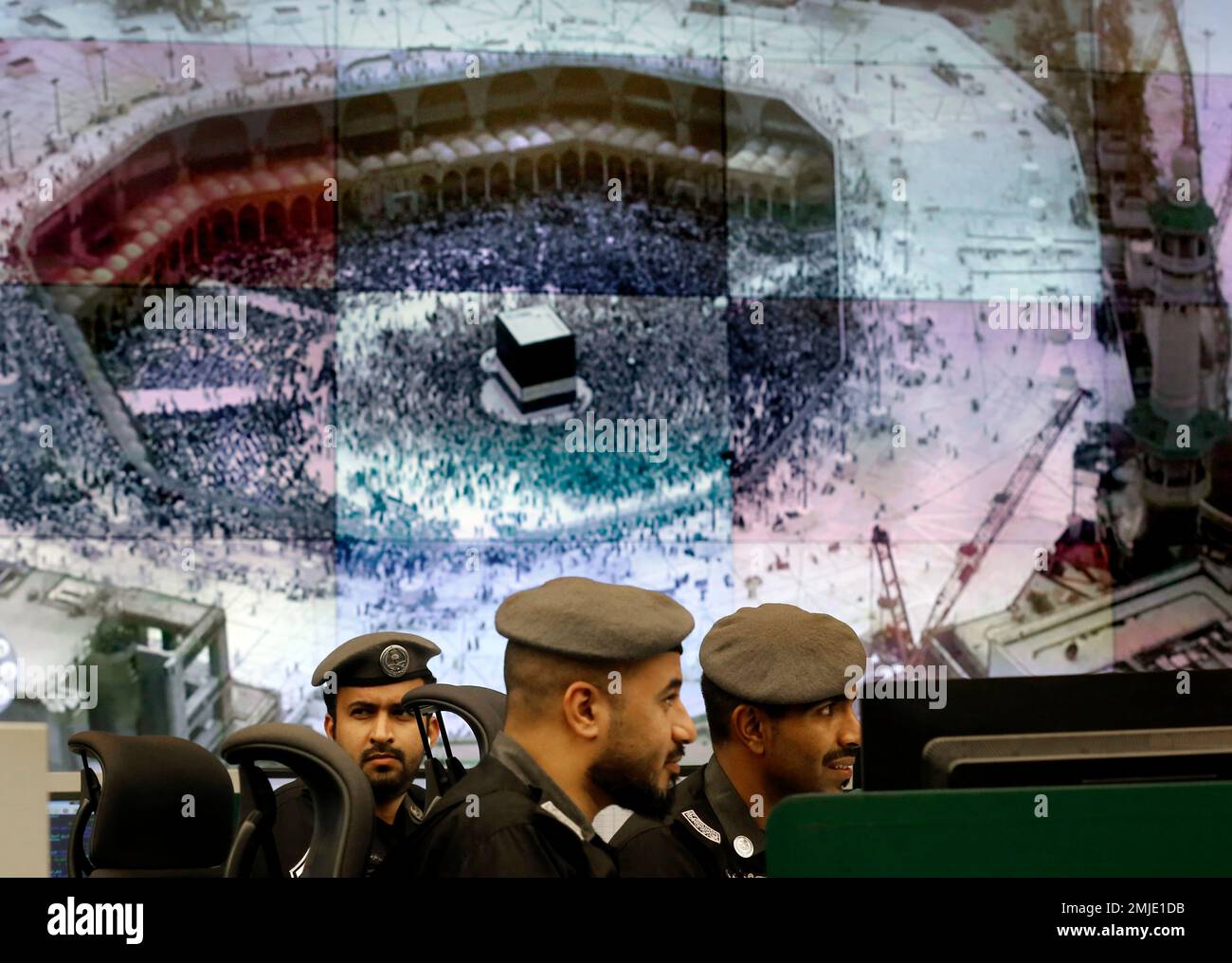 Saudi police officers monitor screens displaying the Grand Mosque, at ...